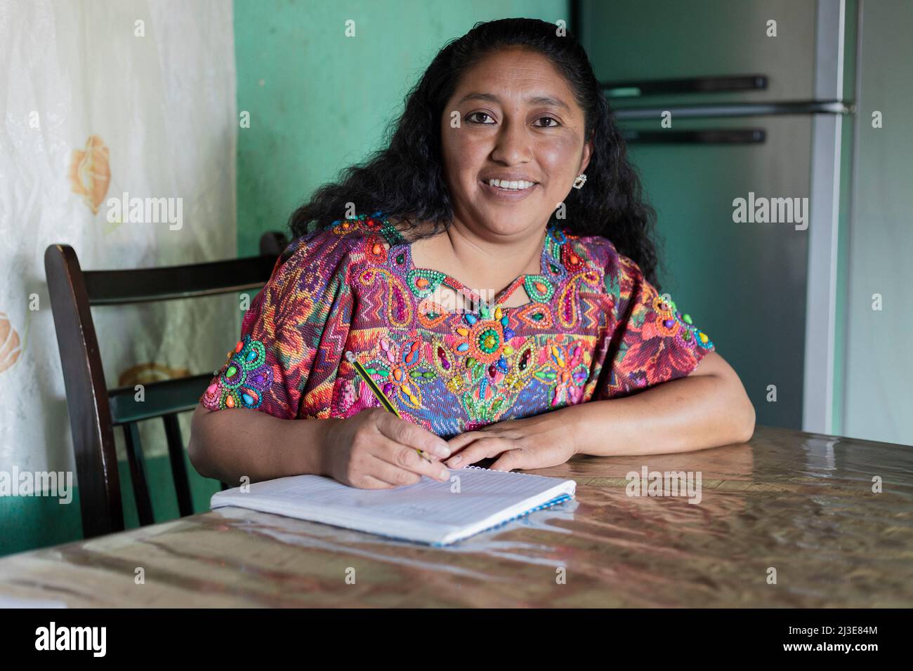 Hispanic adult woman studying at home - family mother handling ...