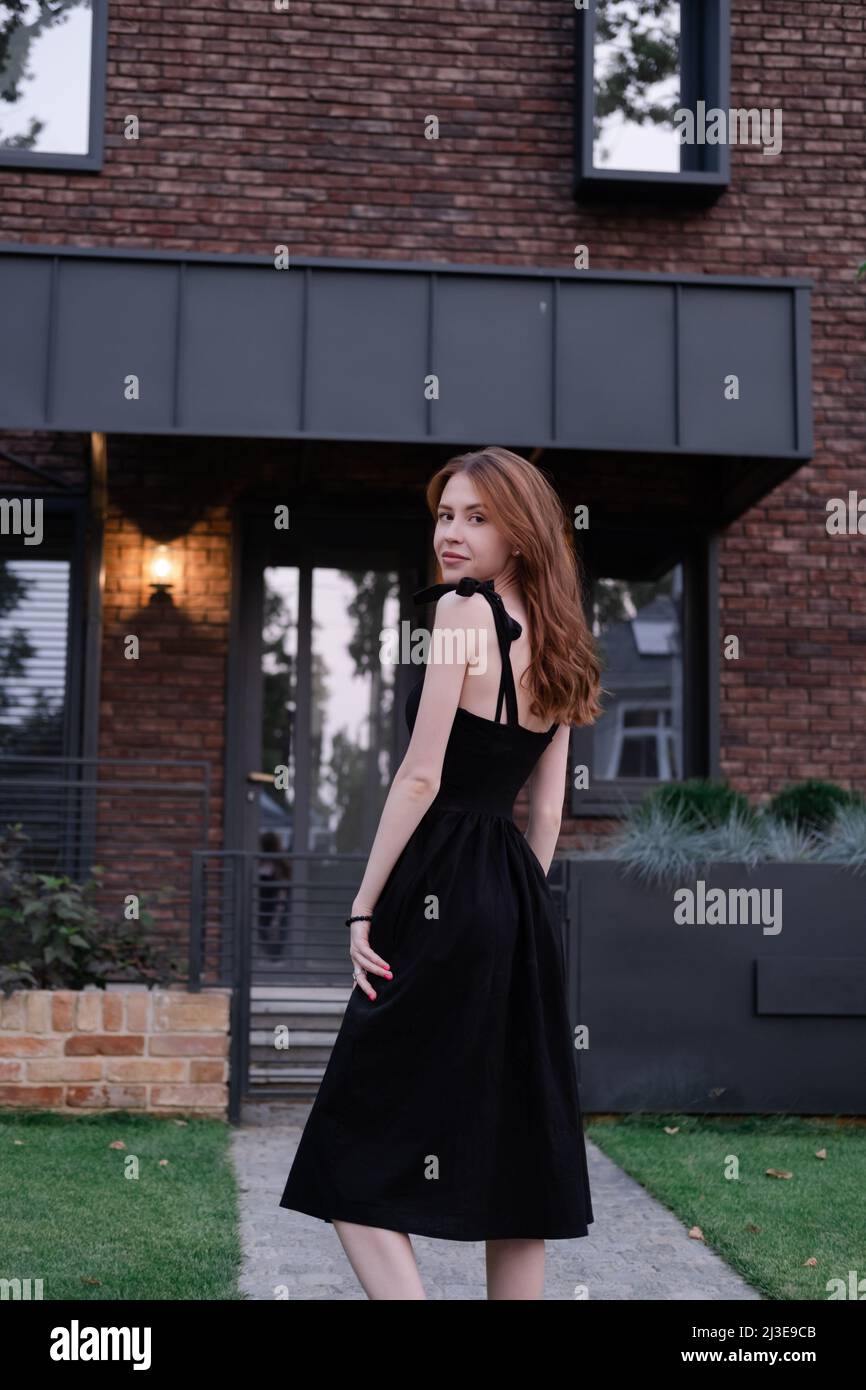 confident single woman near her new home. brown and black modern ...