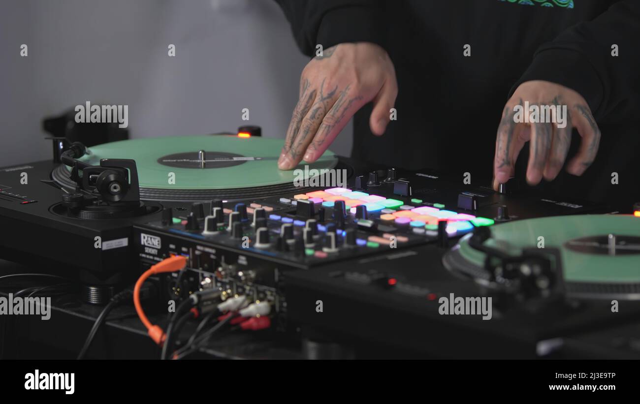 Two DJs are mixing music on console. Art. People are setting up music ...