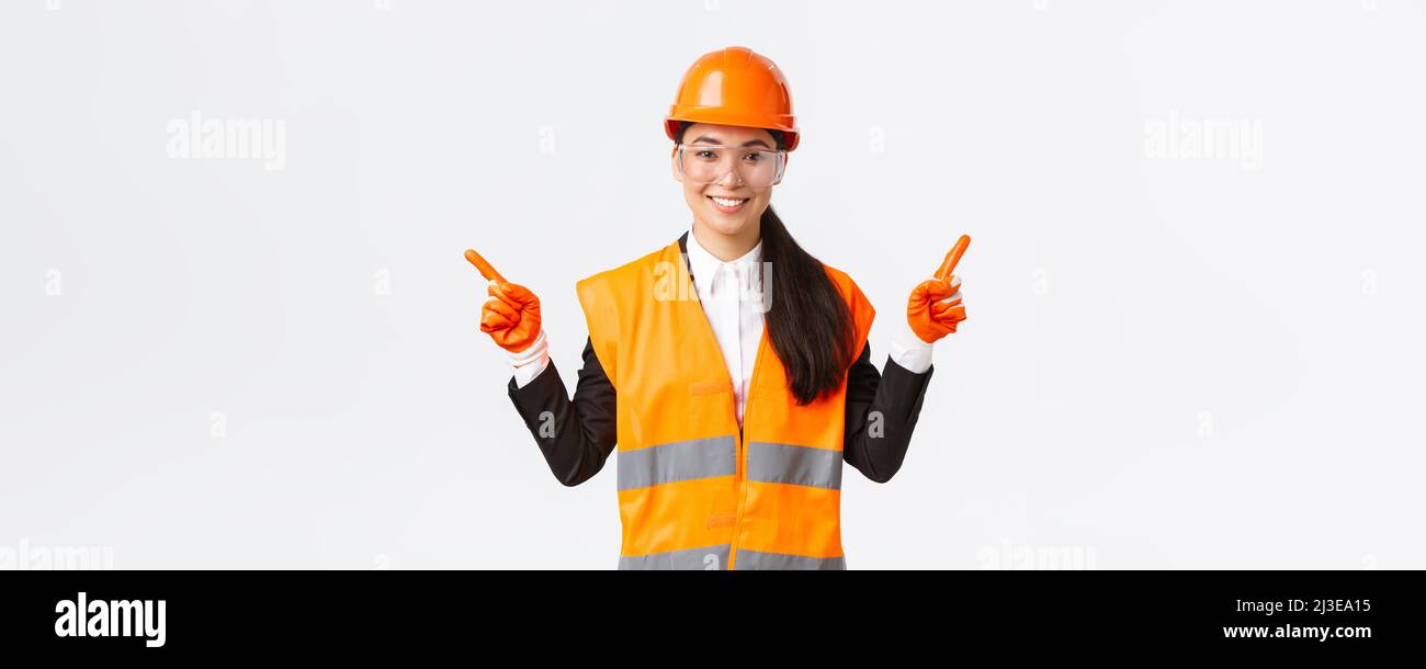 Smiling professional asian female builder, engineer in safety helmet ...