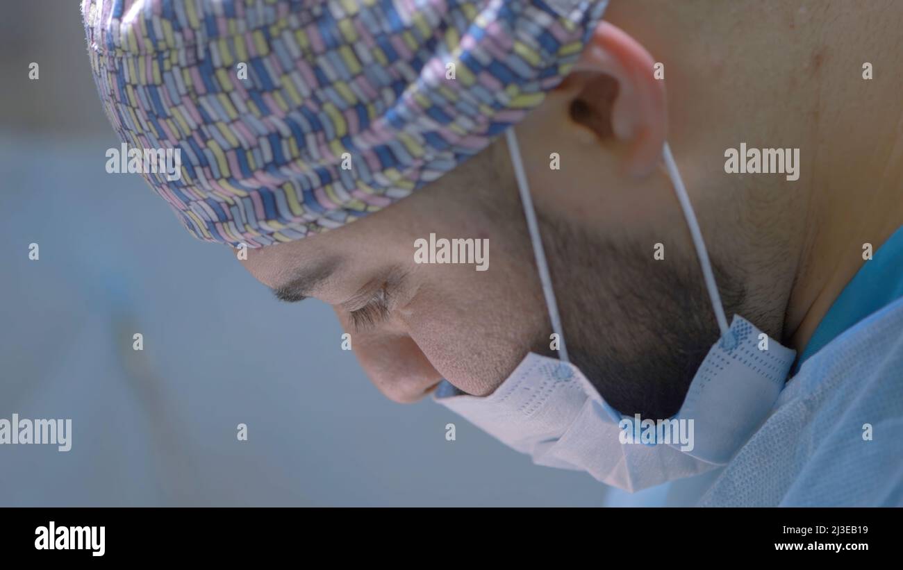 Close up of surgeon in a special uniform performing medical procedure ...