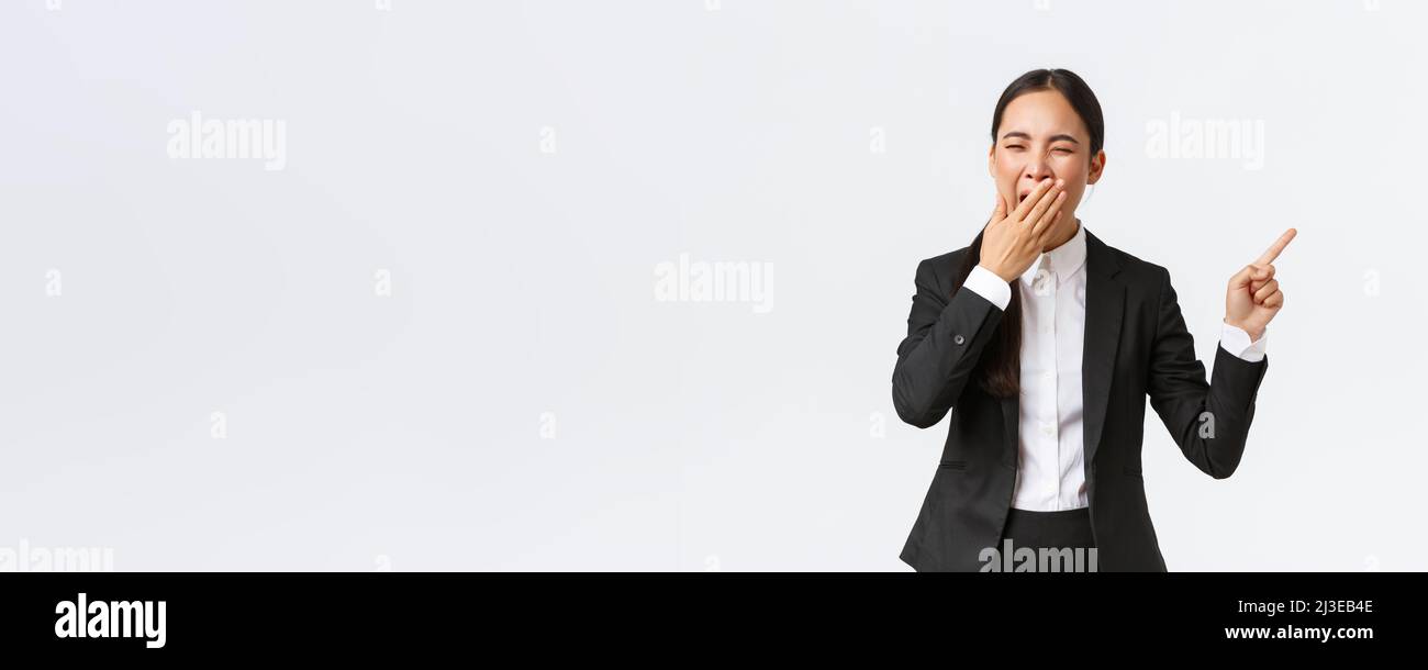 Tired female office manager, entrepreneur in suit pointing finger right ...