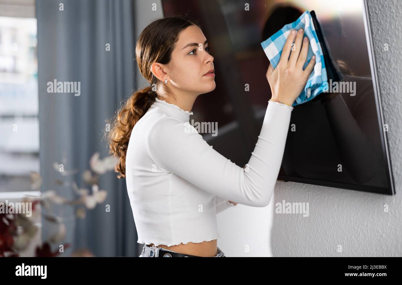 Woman cleaning TV screen in living room Stock Photo - Alamy