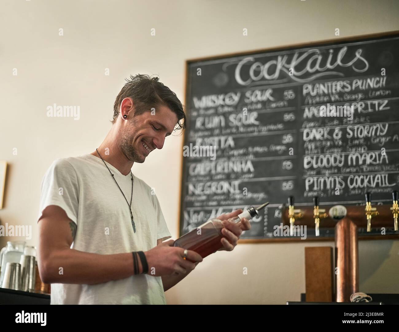 Hes got a new cocktail recipe in mind. Shot of a happy young bartender ...