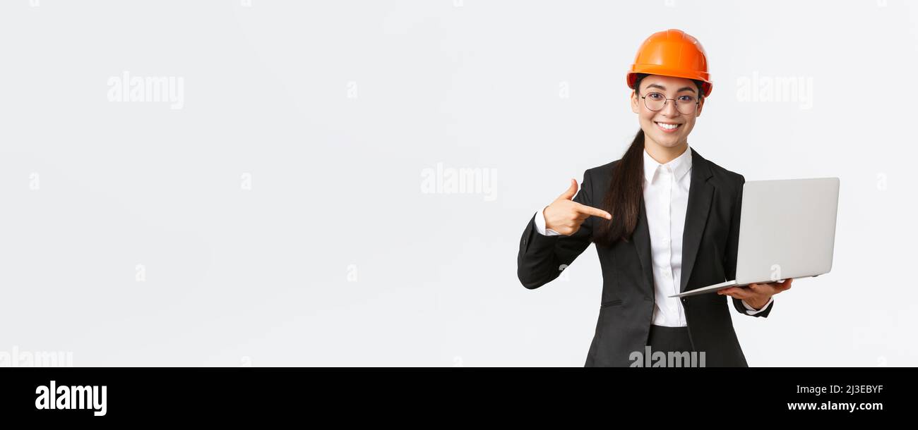 Smiling pleased asian female chief engineer showing chart with ...