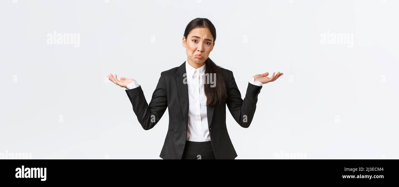 Clueless upset young asian female office worker, manager in black suit ...