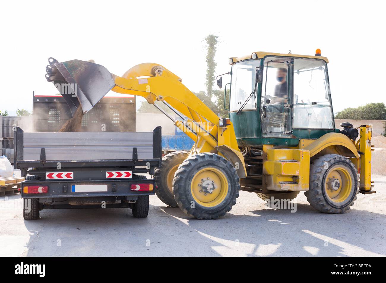 Front loader loads sand into the back of truck Stock Photo - Alamy