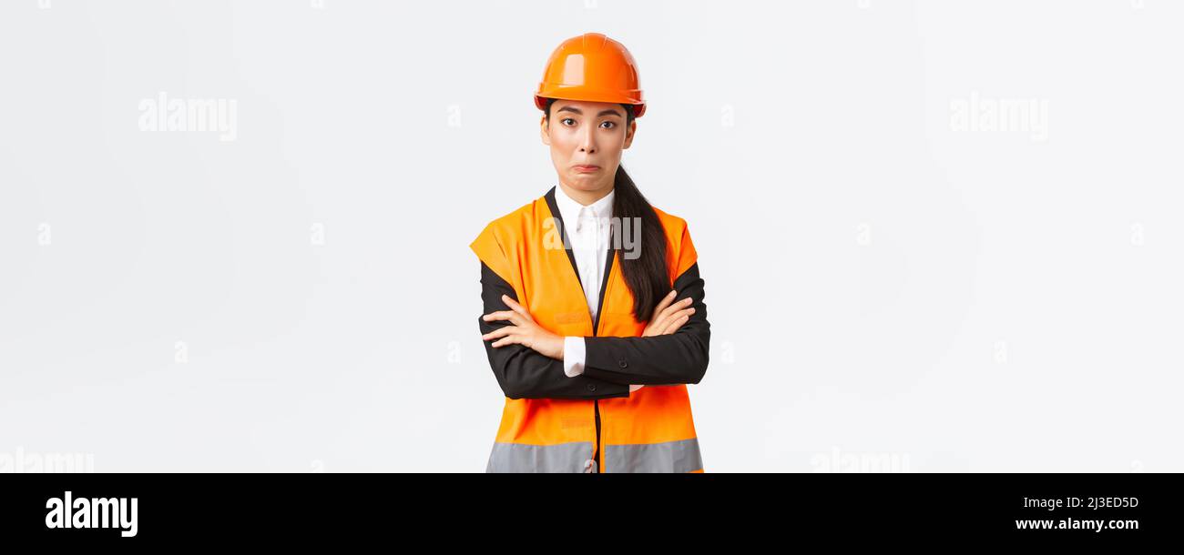 Awkward asian female engineer in reflective jacket, safety helmet ...