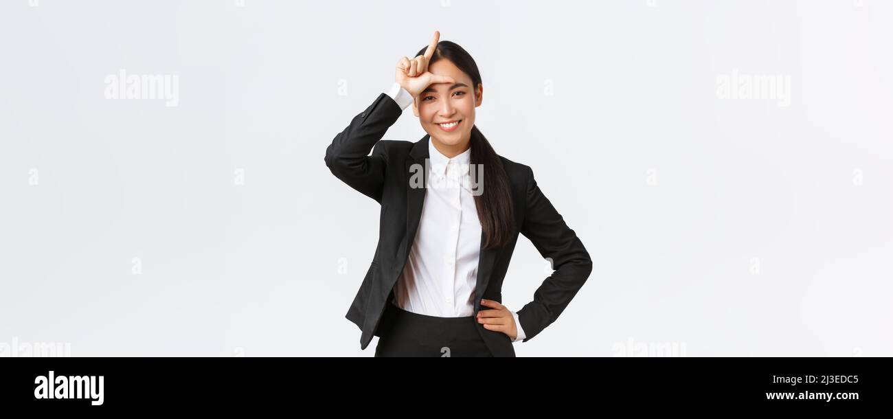 Successful asian businesswoman in black suit mocking her rivals ...