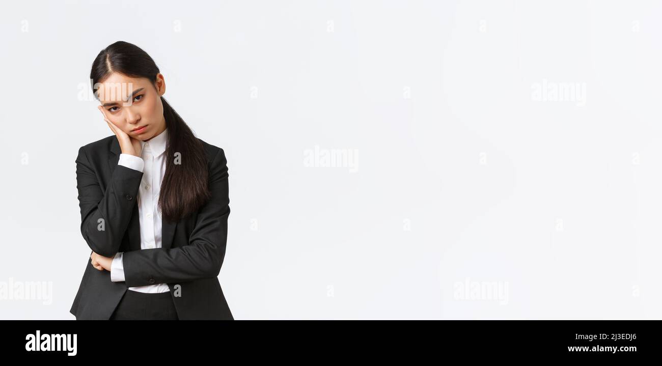 Annoyed and exhausted asian saleswoman looking unamused and bothered ...