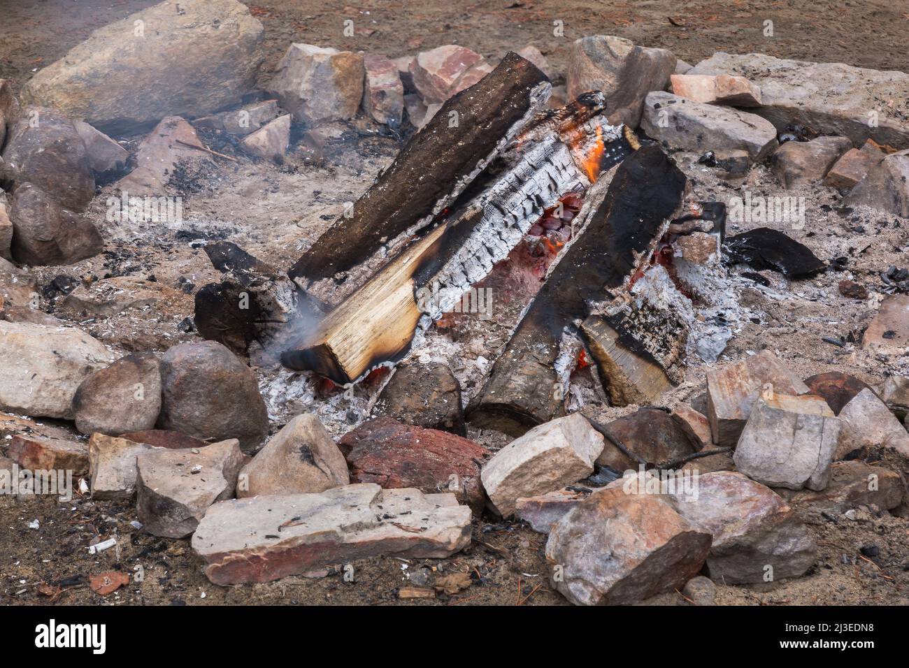 Campfire encircled with rocks on sandy beach Stock Photo - Alamy