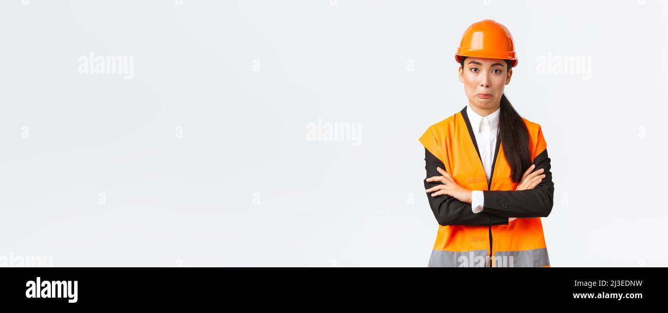 Awkward asian female engineer in reflective jacket, safety helmet ...