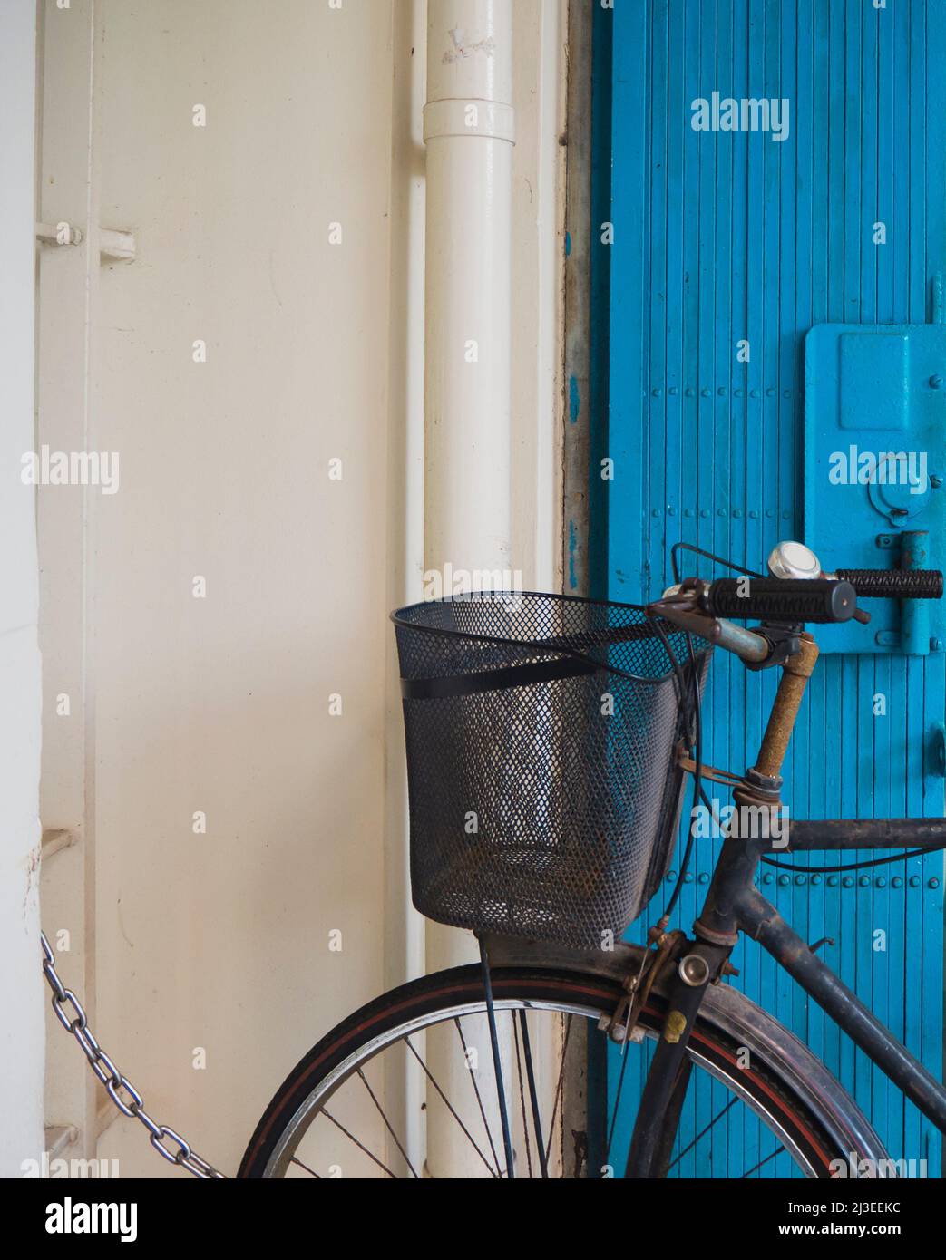 Old vintage bicycle by a blue metal gate Stock Photo - Alamy