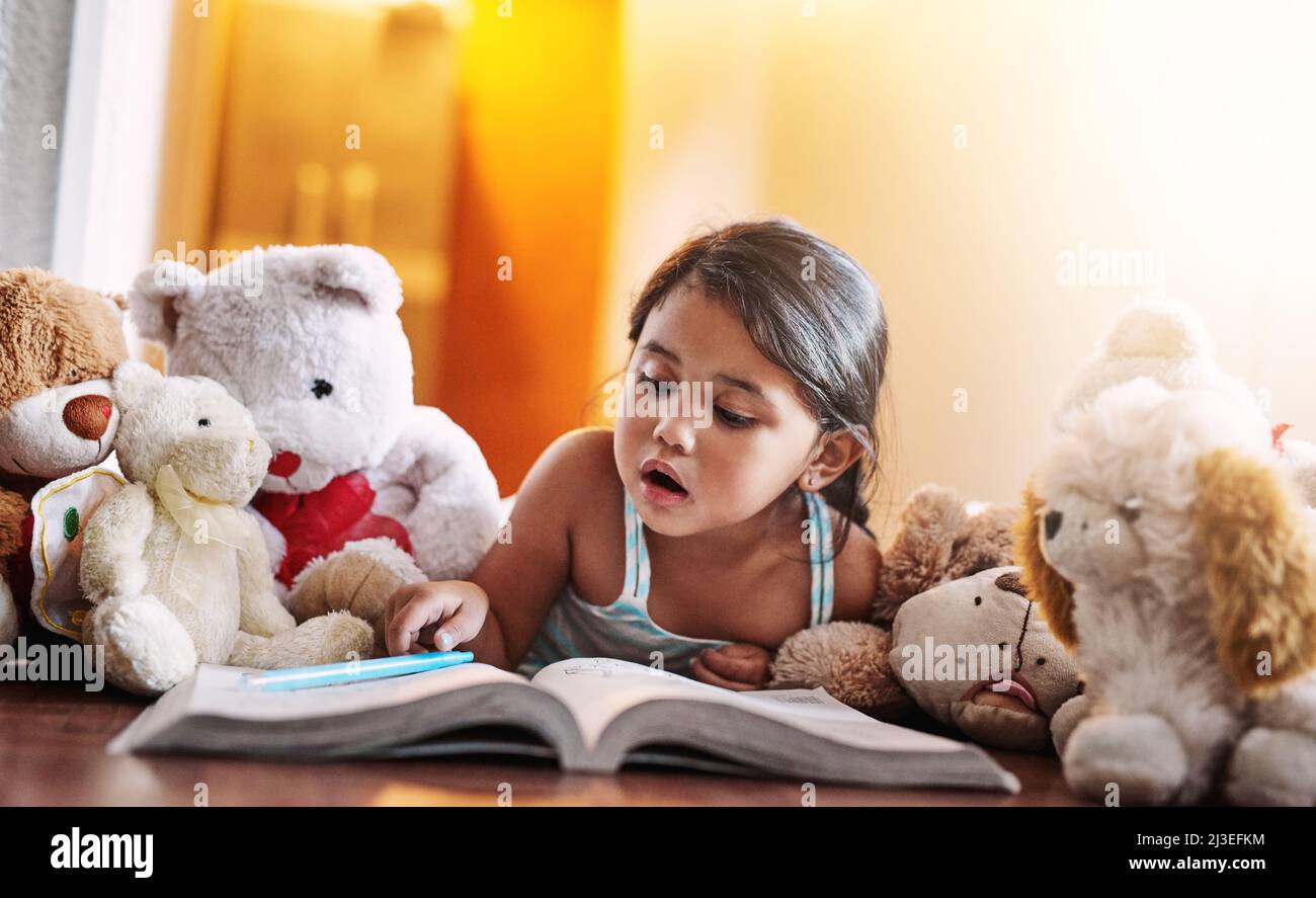 The book has her full attention. Shot of a focused little girl writing ...