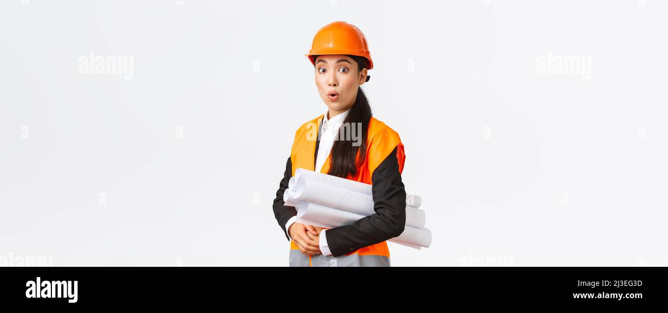 Surprised and excited asian female chief architect in safety helmet and ...