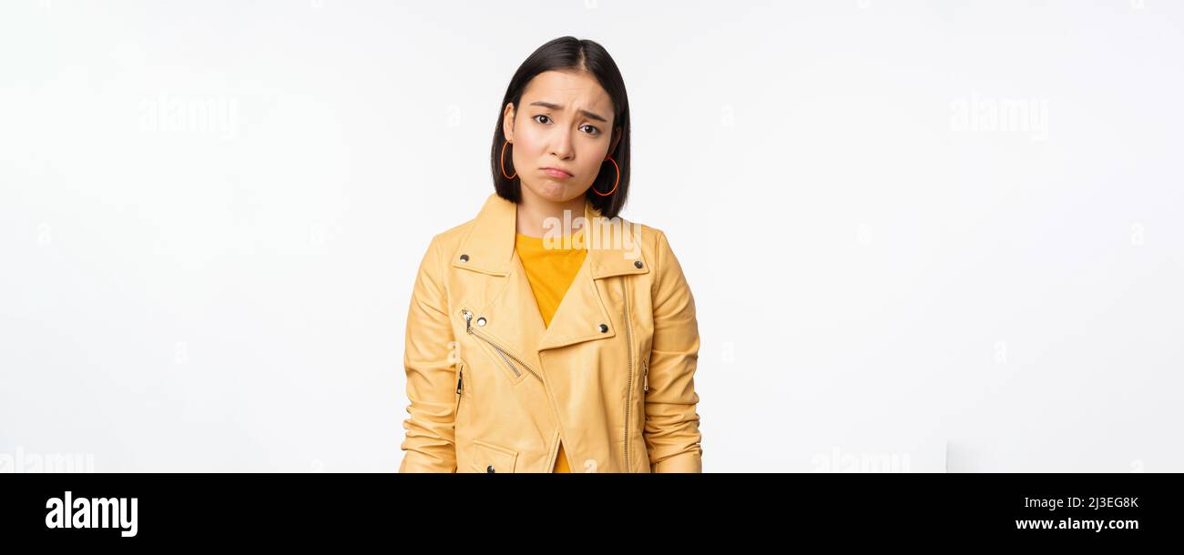 Portrait of sad korean woman sulking, frowning and looking upset ...
