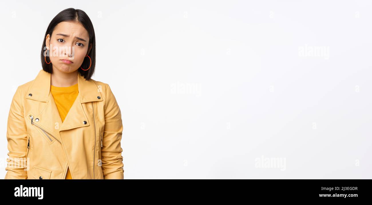 Portrait of sad korean woman sulking, frowning and looking upset ...