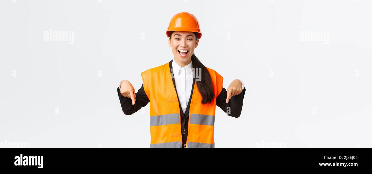 Excited smiling asian female engineer, industrial woman in safety ...