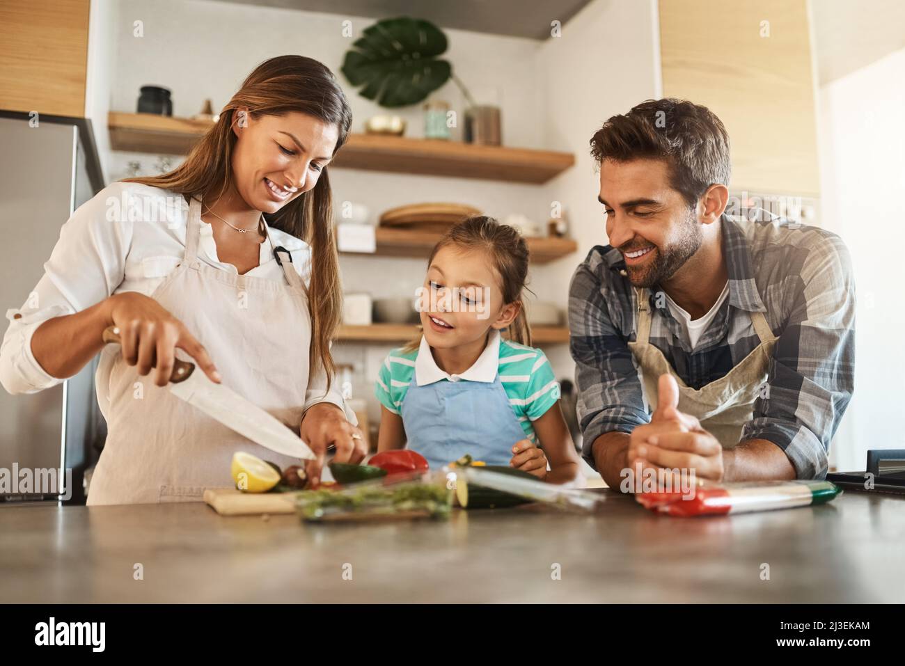 Learning from the best. Shot of a happy young family cooking together ...