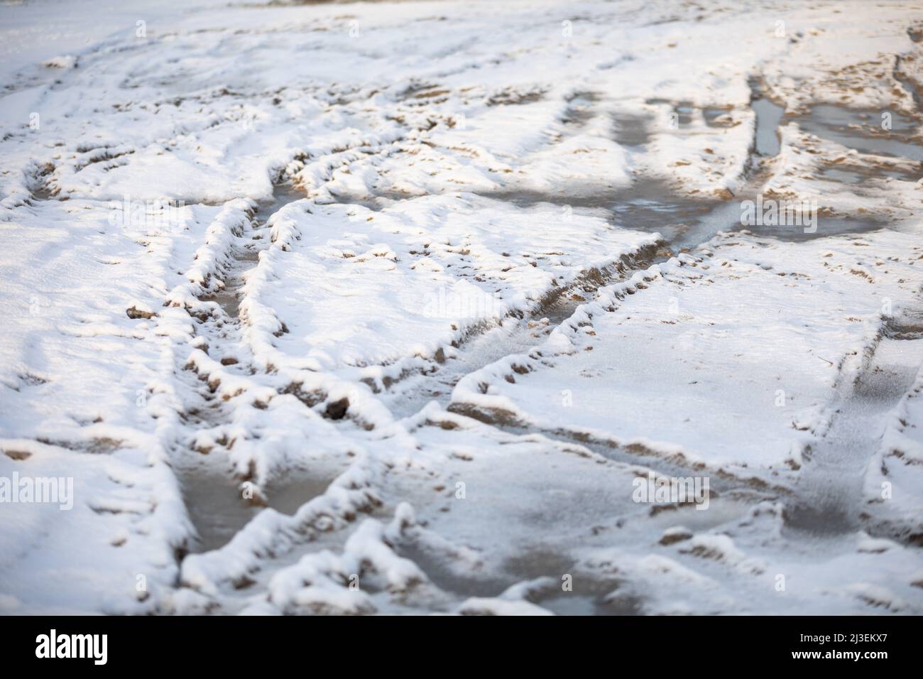 Traces of car ruts on dirt road covered with snow Stock Photo - Alamy