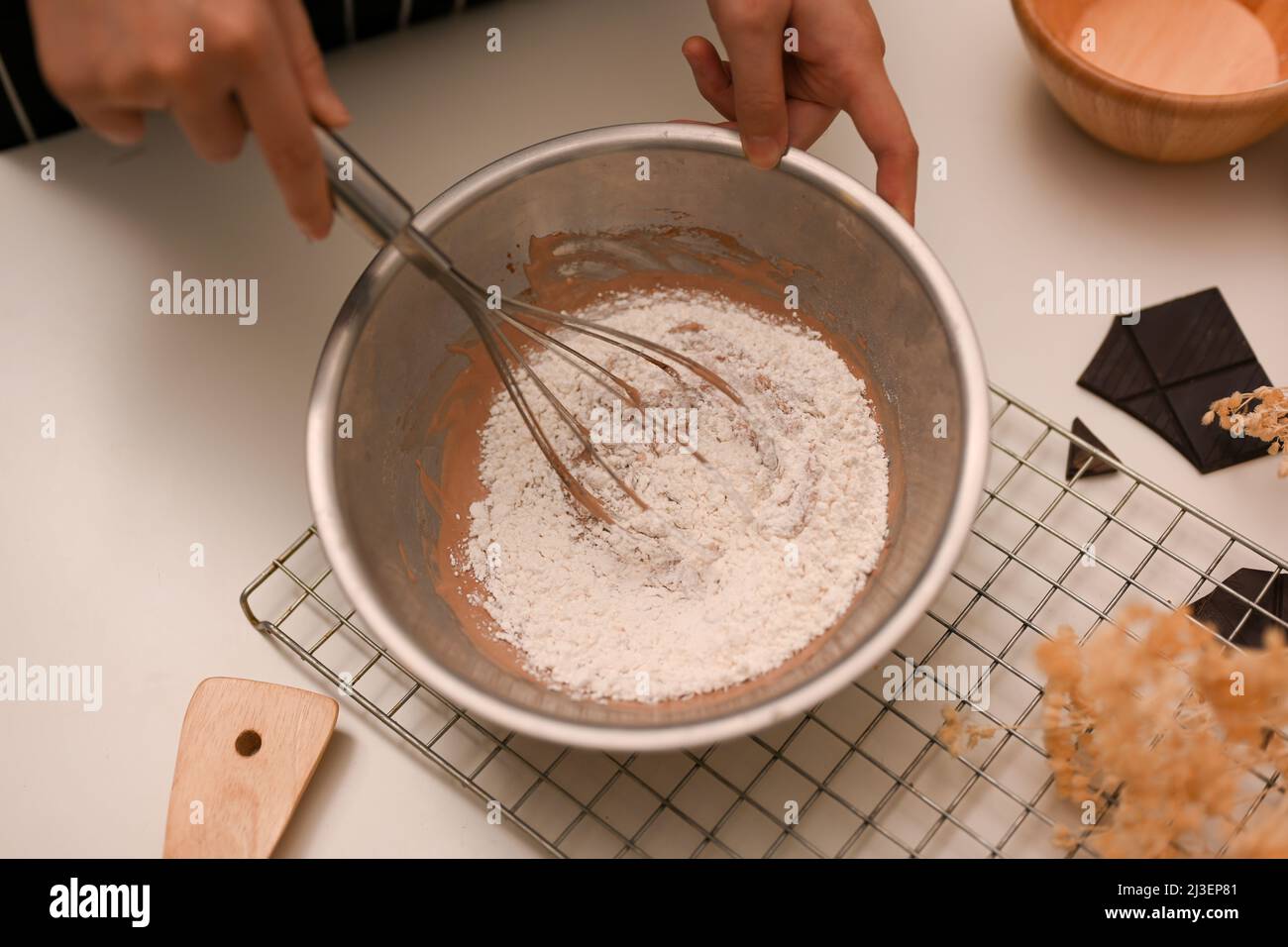 Top view, Female using a whisk to stir cookie flour with a chocolate ...
