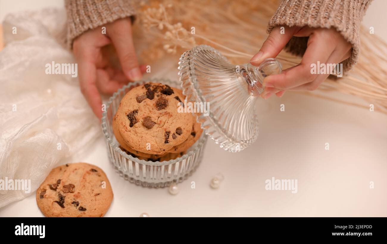 Overhead shot, Female hands open a baked chocolate chip cookies jar on ...