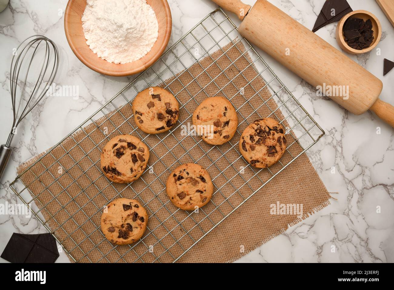Freshly baked chocolate chip cookies on a wire cooling rack with baking ...