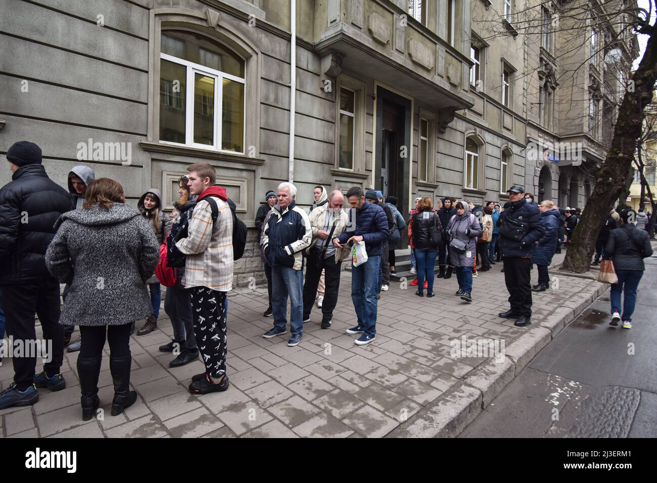 People stand in a line at the UN refugee office in Lviv to register as ...