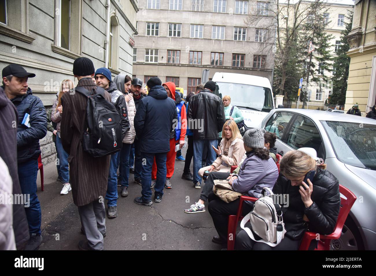 People stand in a line at the UN refugee office in Lviv to register as ...