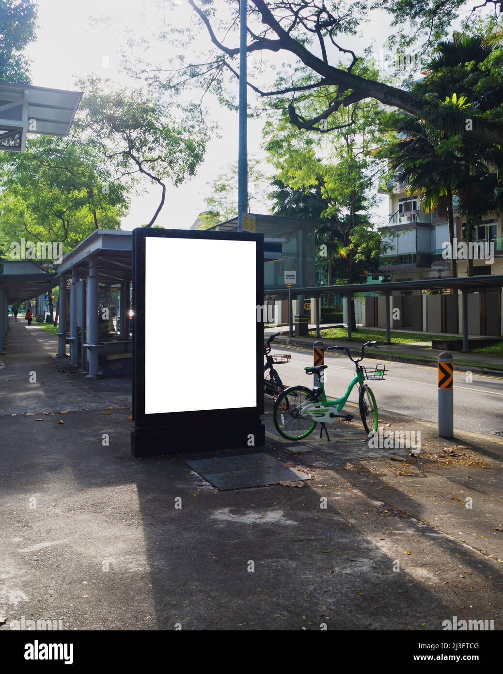 Vertical bus stop billboard ad mock up in a residential area surrounded ...