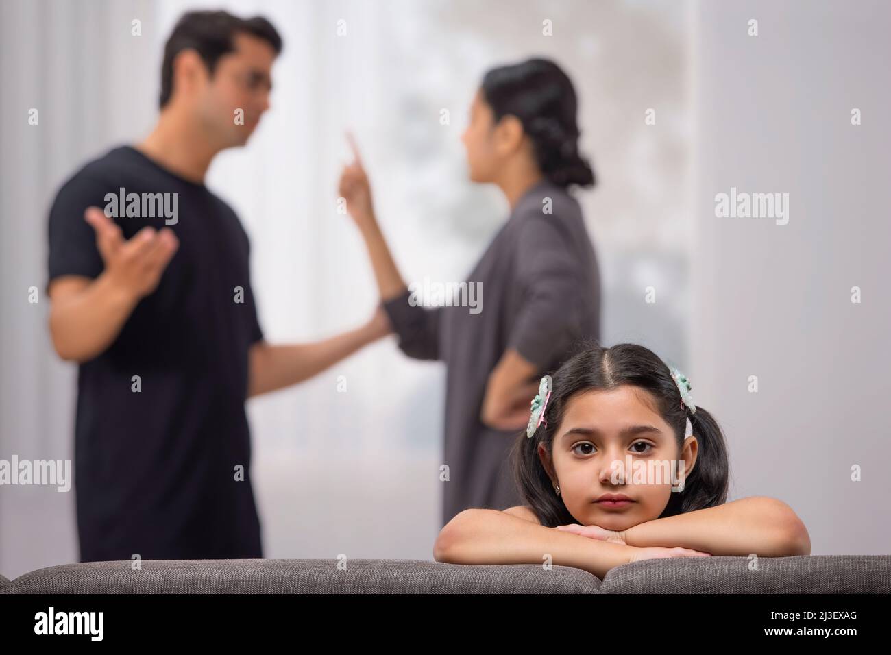 Portrait of a sad girl child with resting her chin on hands and parent ...