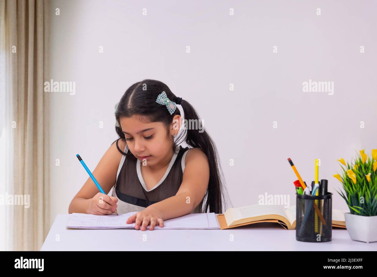 Pretty little girl doing homework at home Stock Photo - Alamy