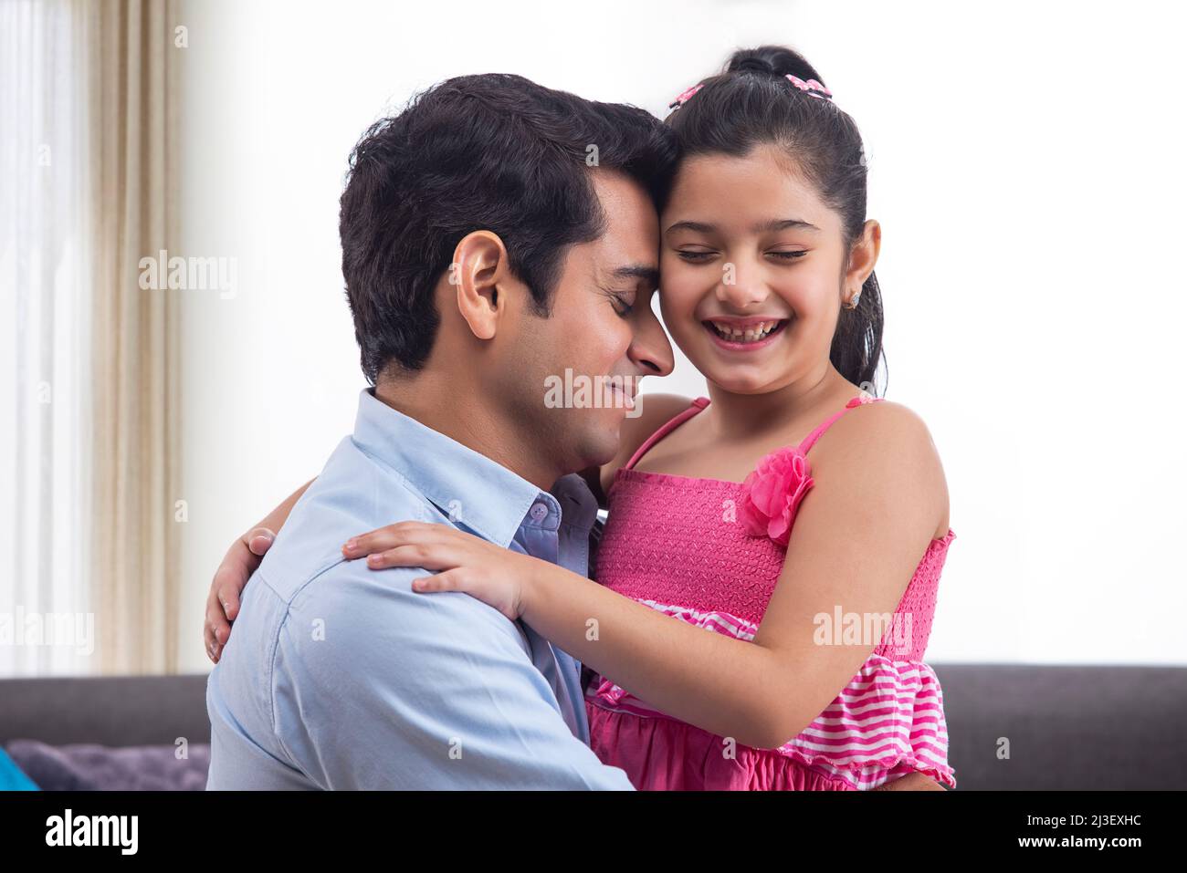 Father and daughter hugging each other at home Stock Photo - Alamy