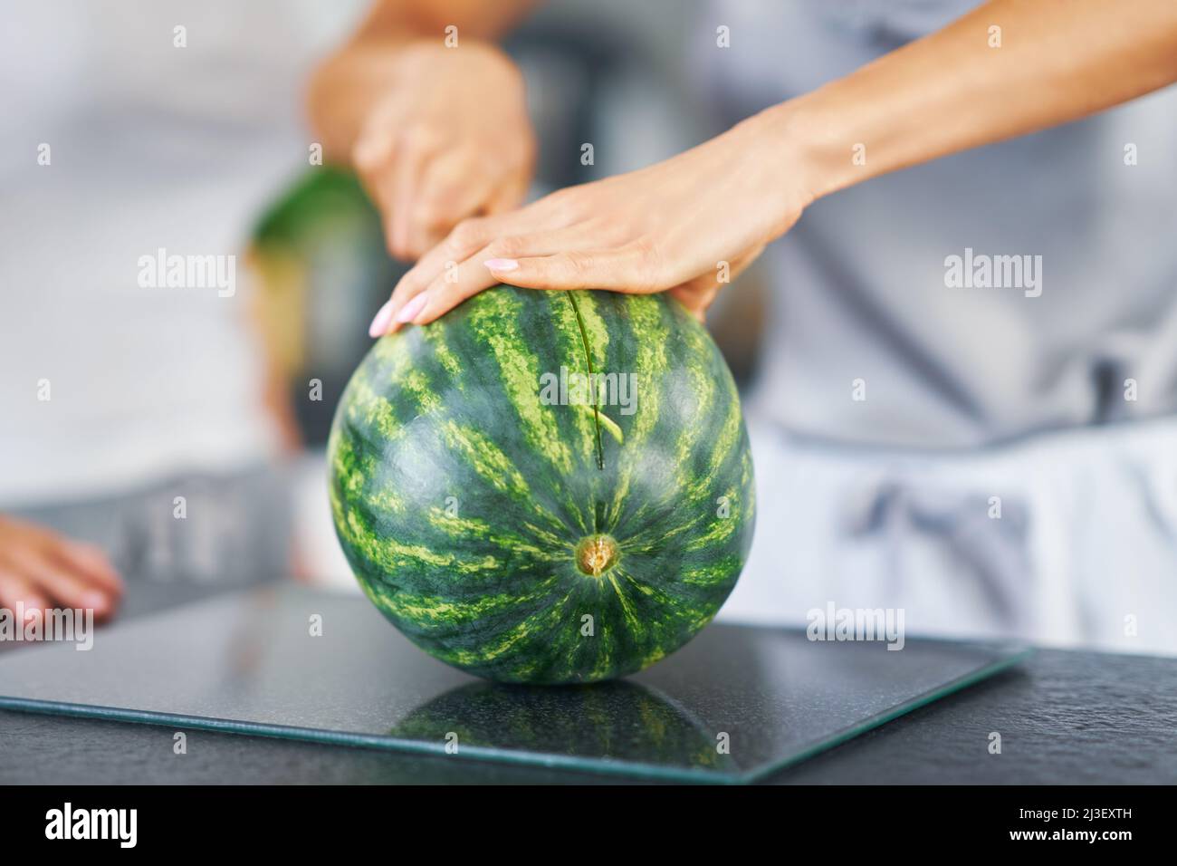 Nice adult woman with watermelon in the kitchen Stock Photo - Alamy