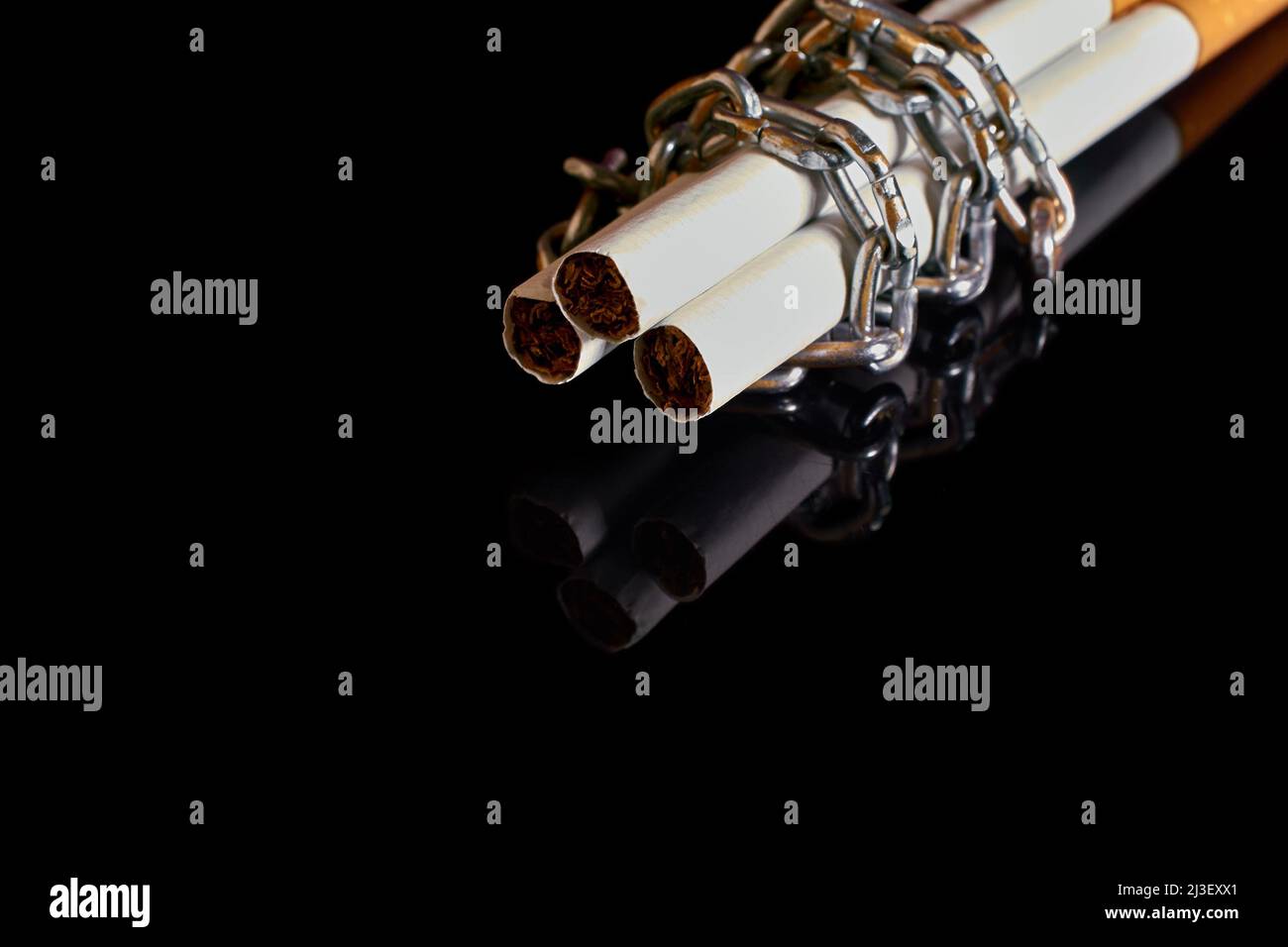 Nicotine addiction. Three cigarettes rewound by a chain Stock Photo - Alamy