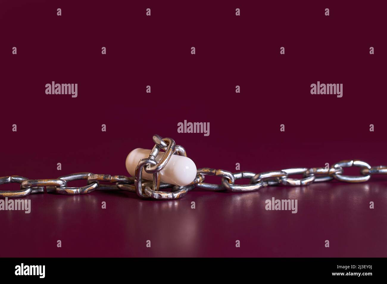 Drug addiction. White capsule rewound by a chain Stock Photo - Alamy