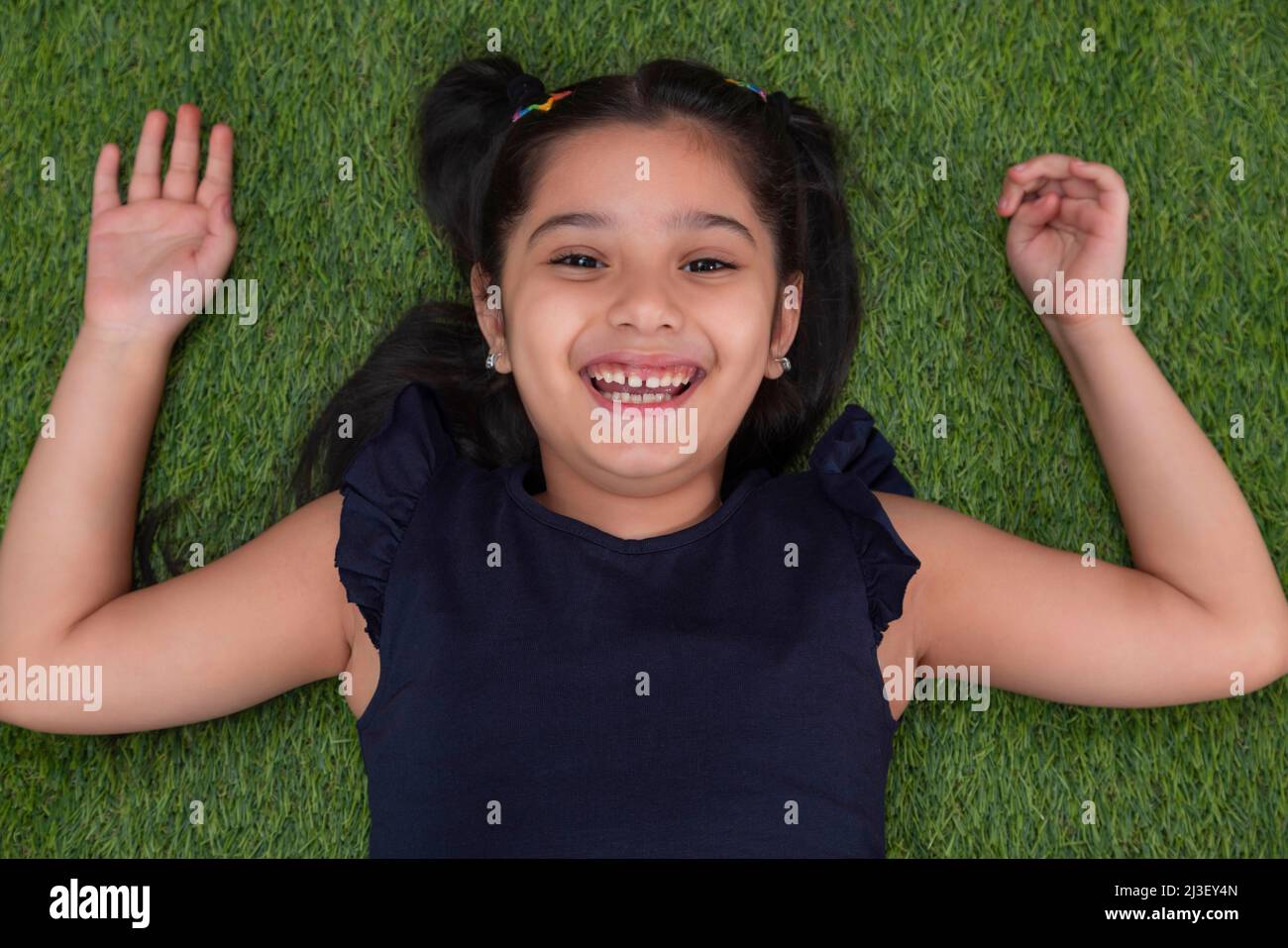 Overhead view of girl child lying on grass Stock Photo - Alamy