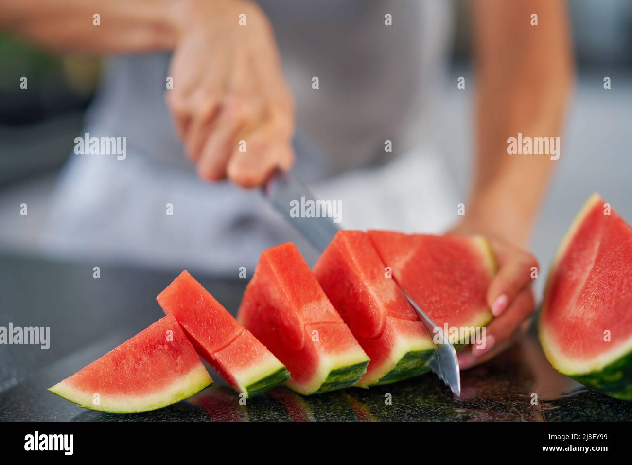 Nice adult woman with watermelon in the kitchen Stock Photo - Alamy
