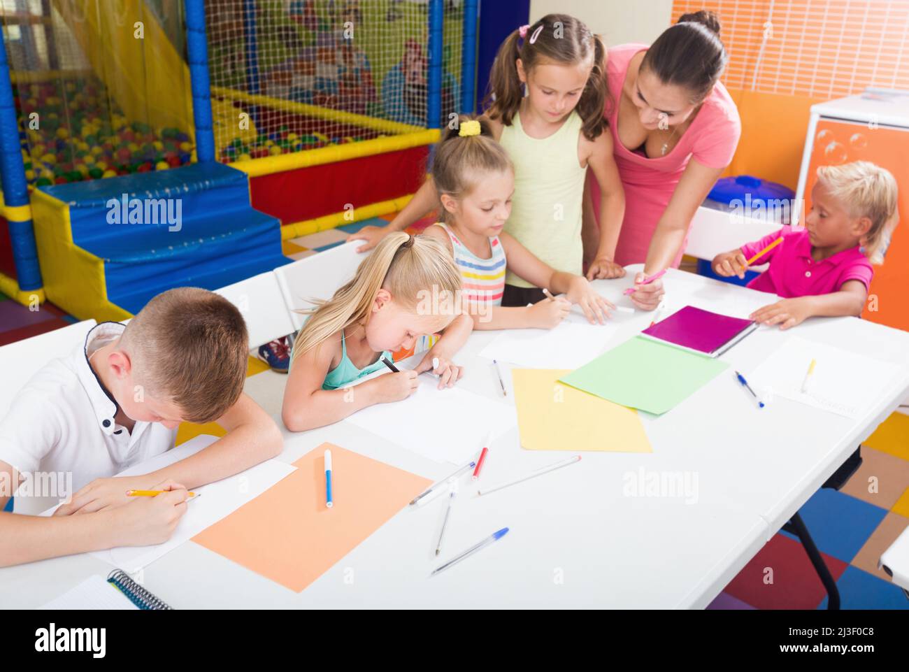 Positive children drawing together on lesson Stock Photo - Alamy