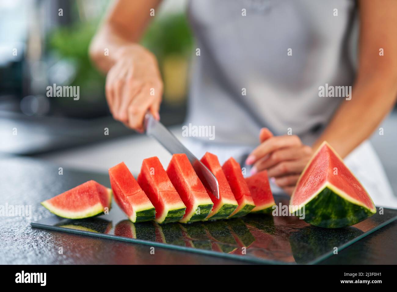 Nice adult woman with watermelon in the kitchen Stock Photo - Alamy