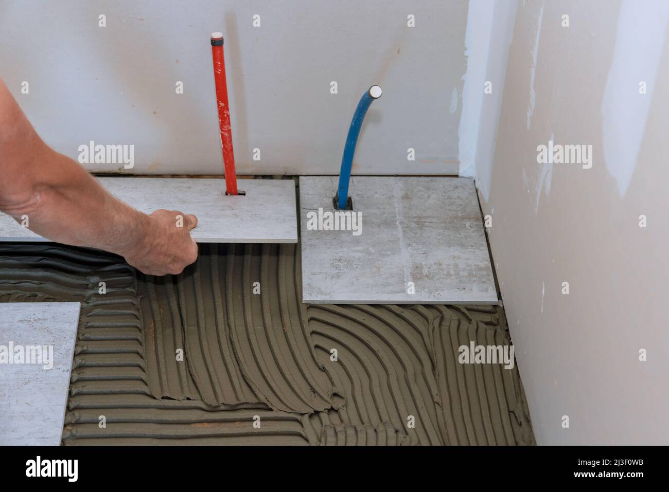 Working tiles lay a tile on the floor Stock Photo - Alamy