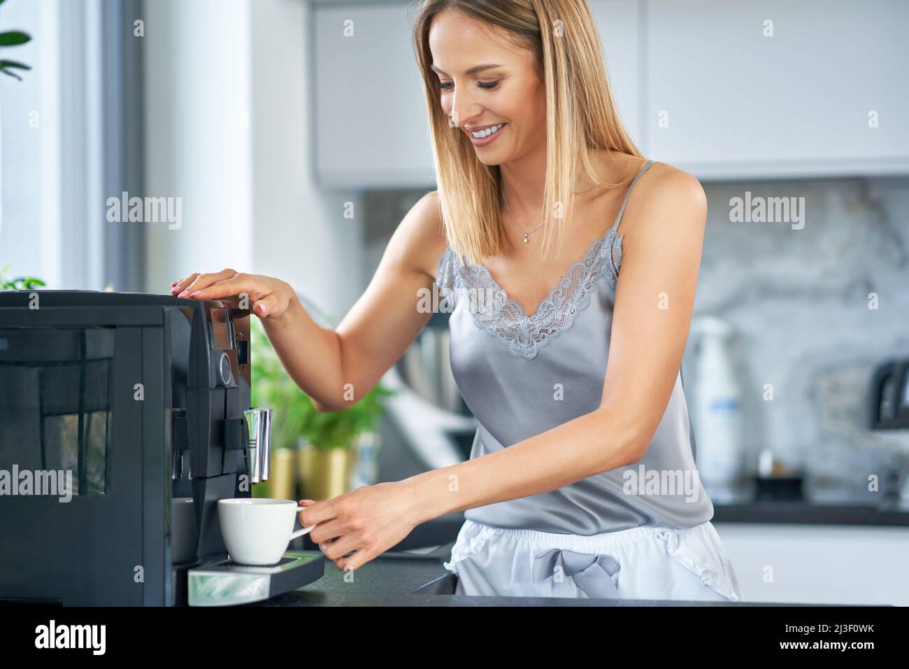 Nice woman making coffee in the kitchen Stock Photo - Alamy