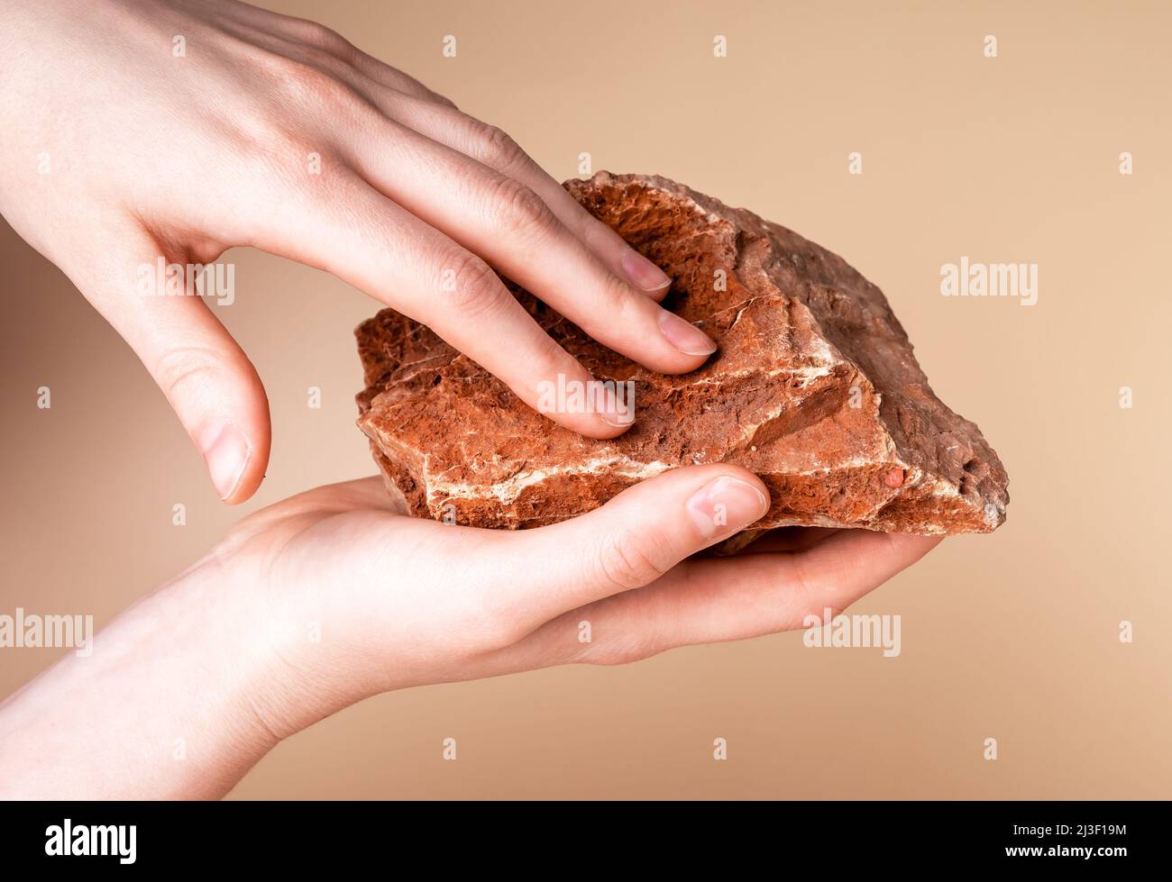 Woman hands holding red stone. Sense of touch and receiving tactile ...