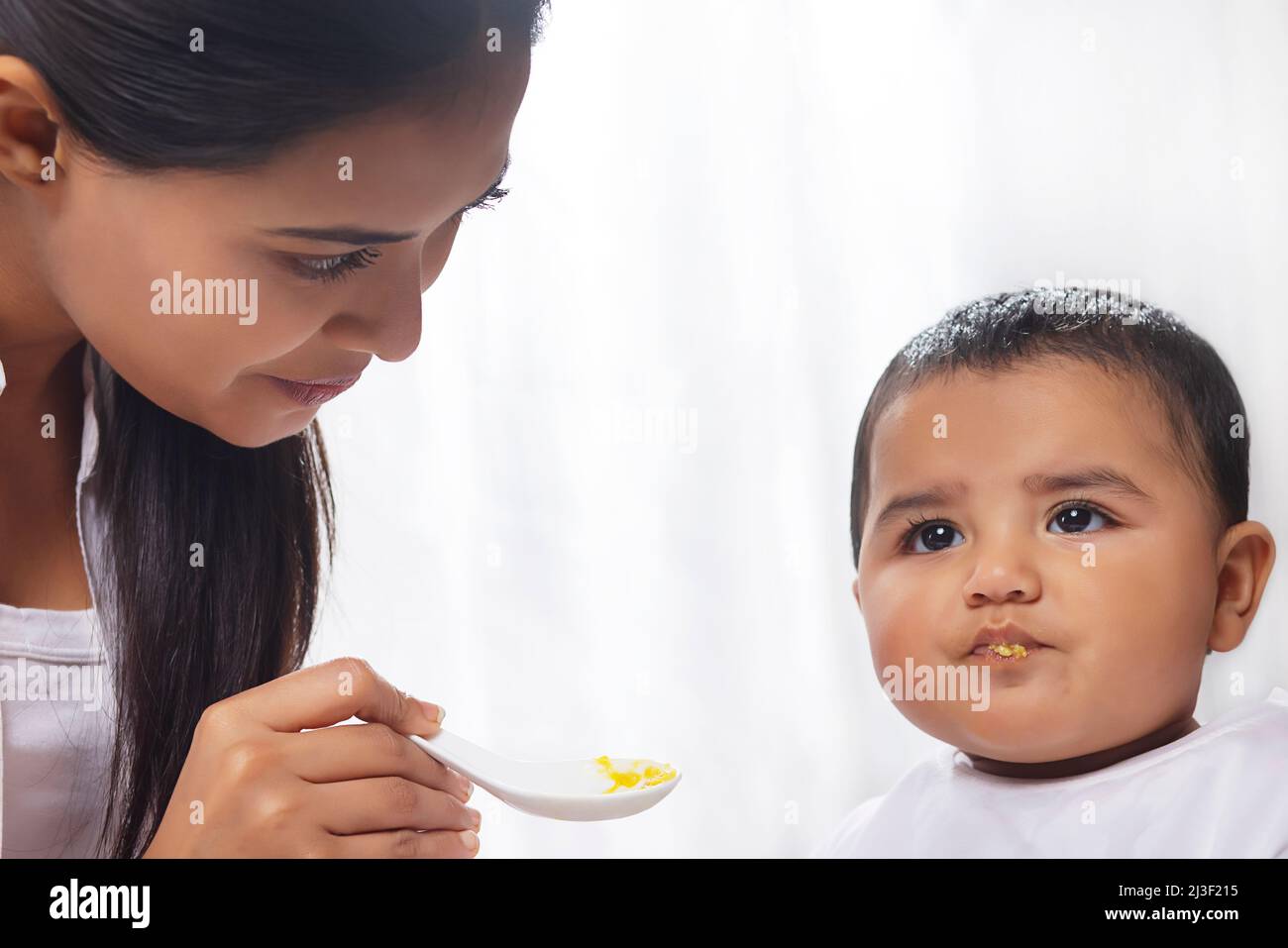 Mother feeding indian kid spoon hi-res stock photography and images - Alamy