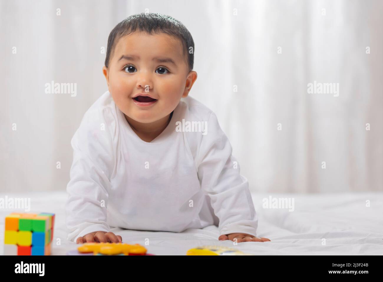 Cute little child crawling on bed alone Stock Photo - Alamy