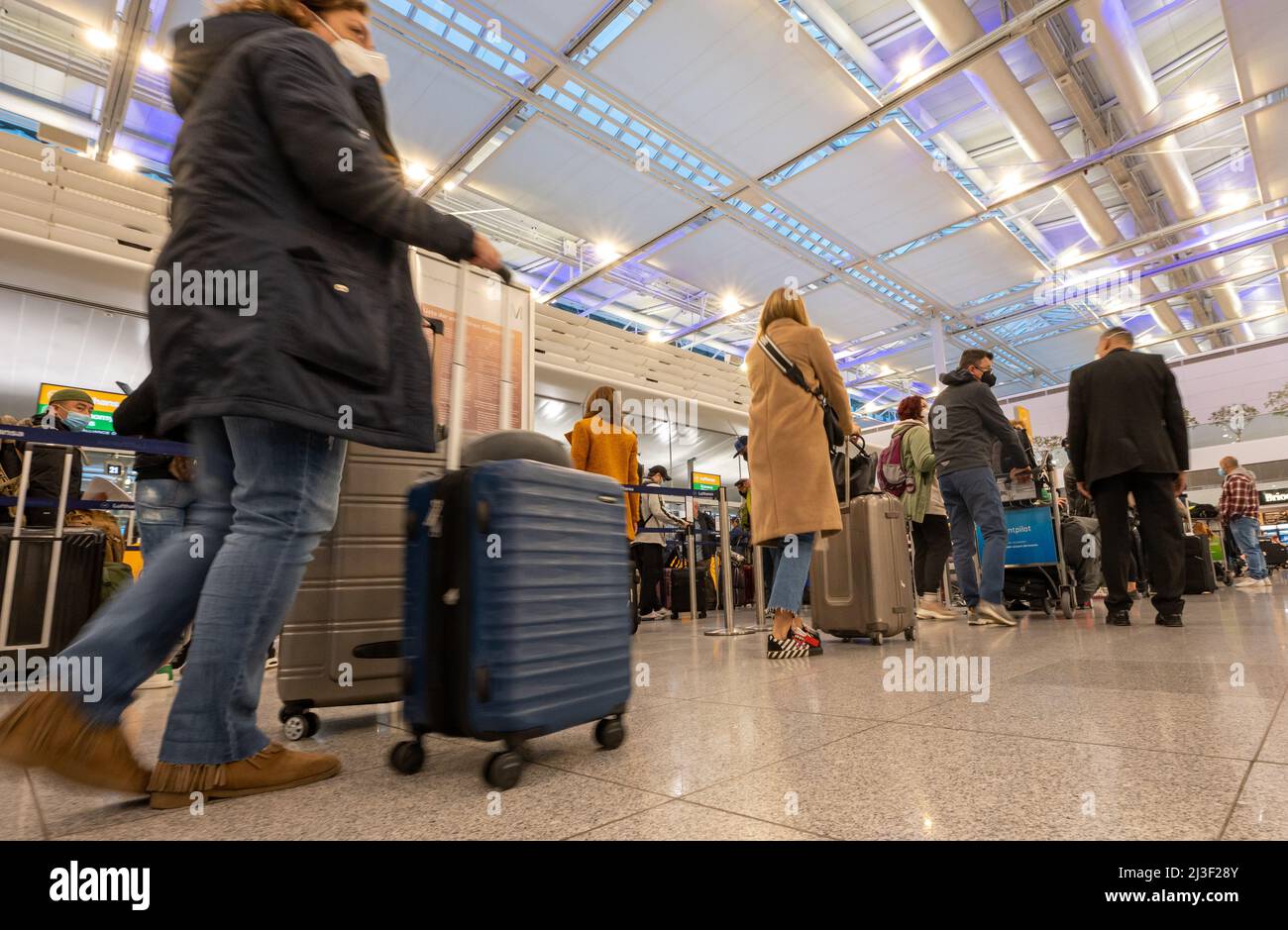 Munich, Germany. 08th Apr, 2022. Airline passengers stand at a check-in ...