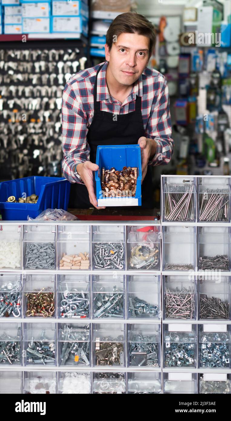 Man standing near the counter and selling details for plumbing in ...