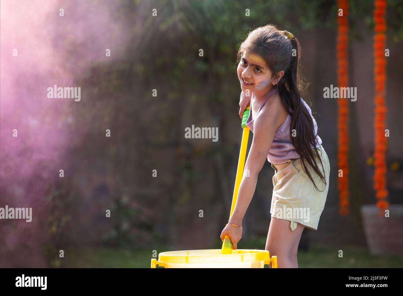 Little girl child celebrating Holi with pichkari and water colour Stock ...