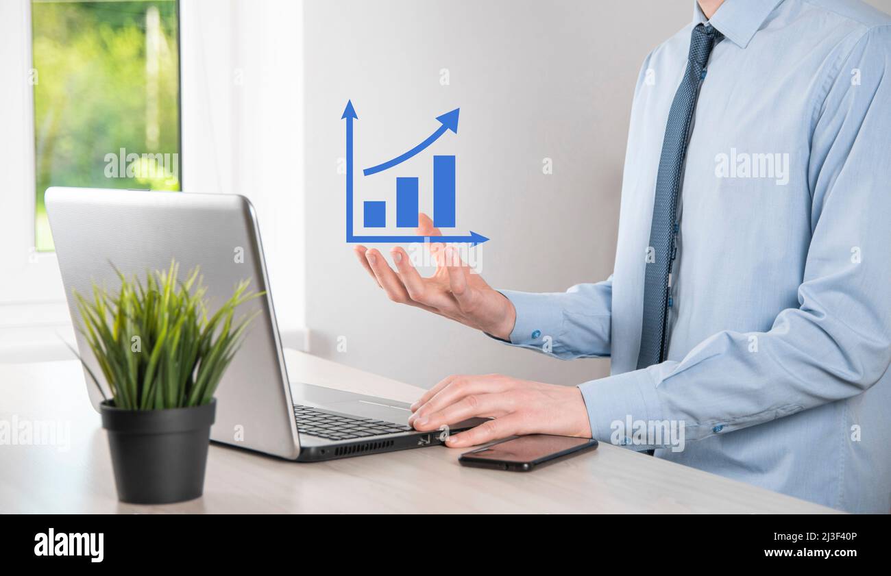 Business man holding holographic graphs and stock market statistics ...