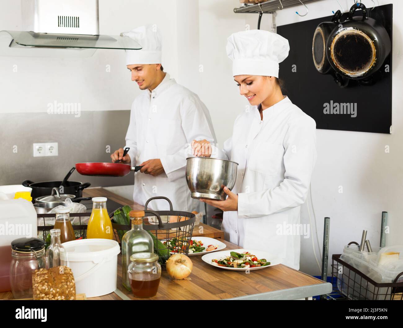 Two chefs cooking food Stock Photo - Alamy